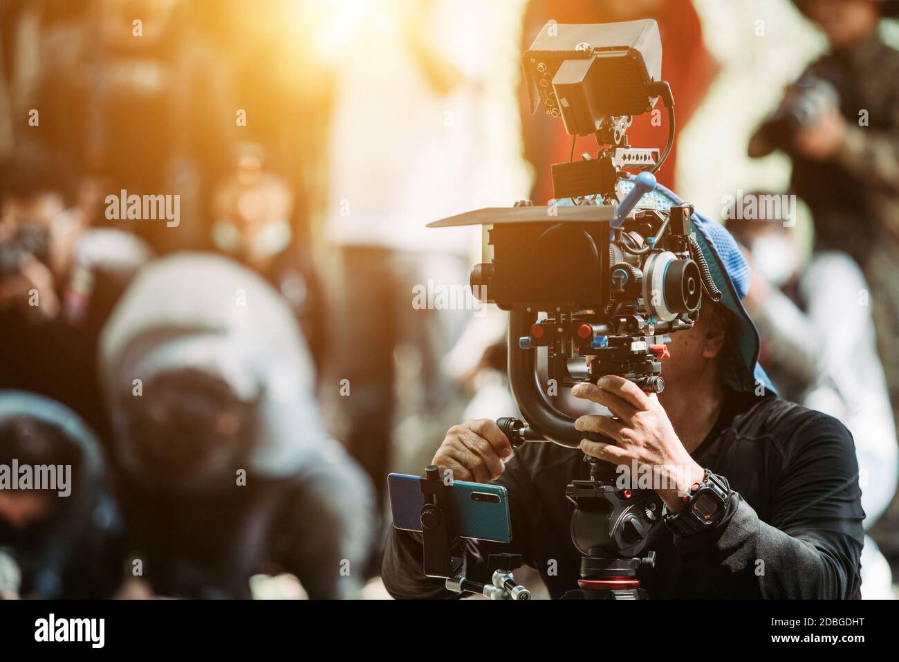 Cameraman operating camera shooting with cinema camera Stock Photo - Alamy