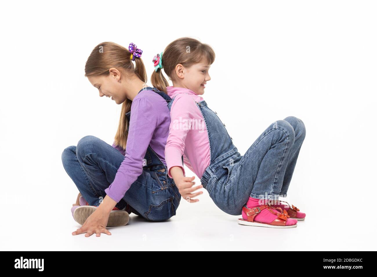 Children sitting on the floor have fun pushing their backs, isolated on ...