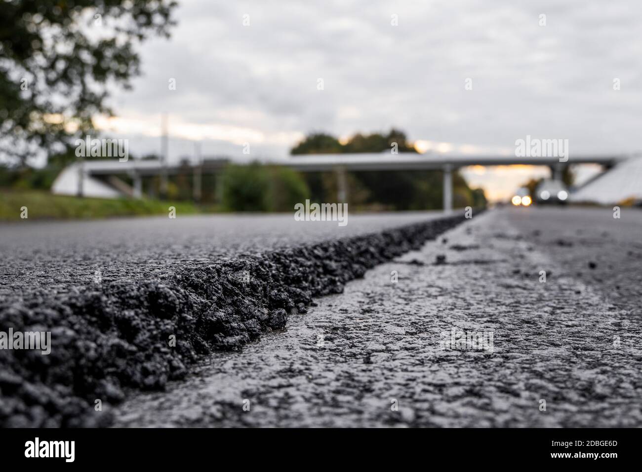 A large layer of fresh hot asphalt. Layer of asphalt raw material in a ...