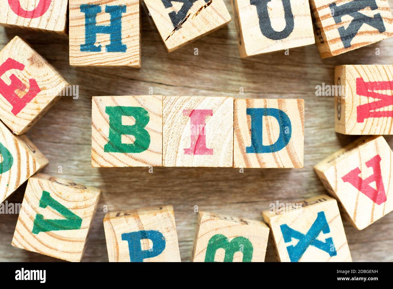 Alphabet letter block in word bid with another on wood background Stock ...