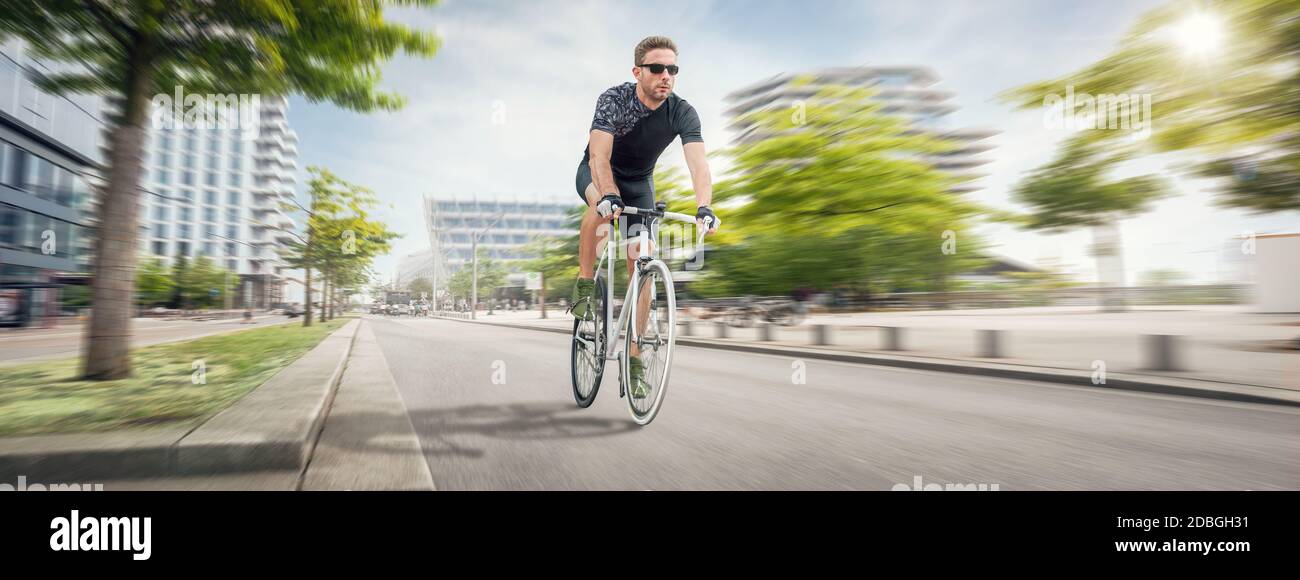 Athletic cyclist riding in the city Stock Photo - Alamy
