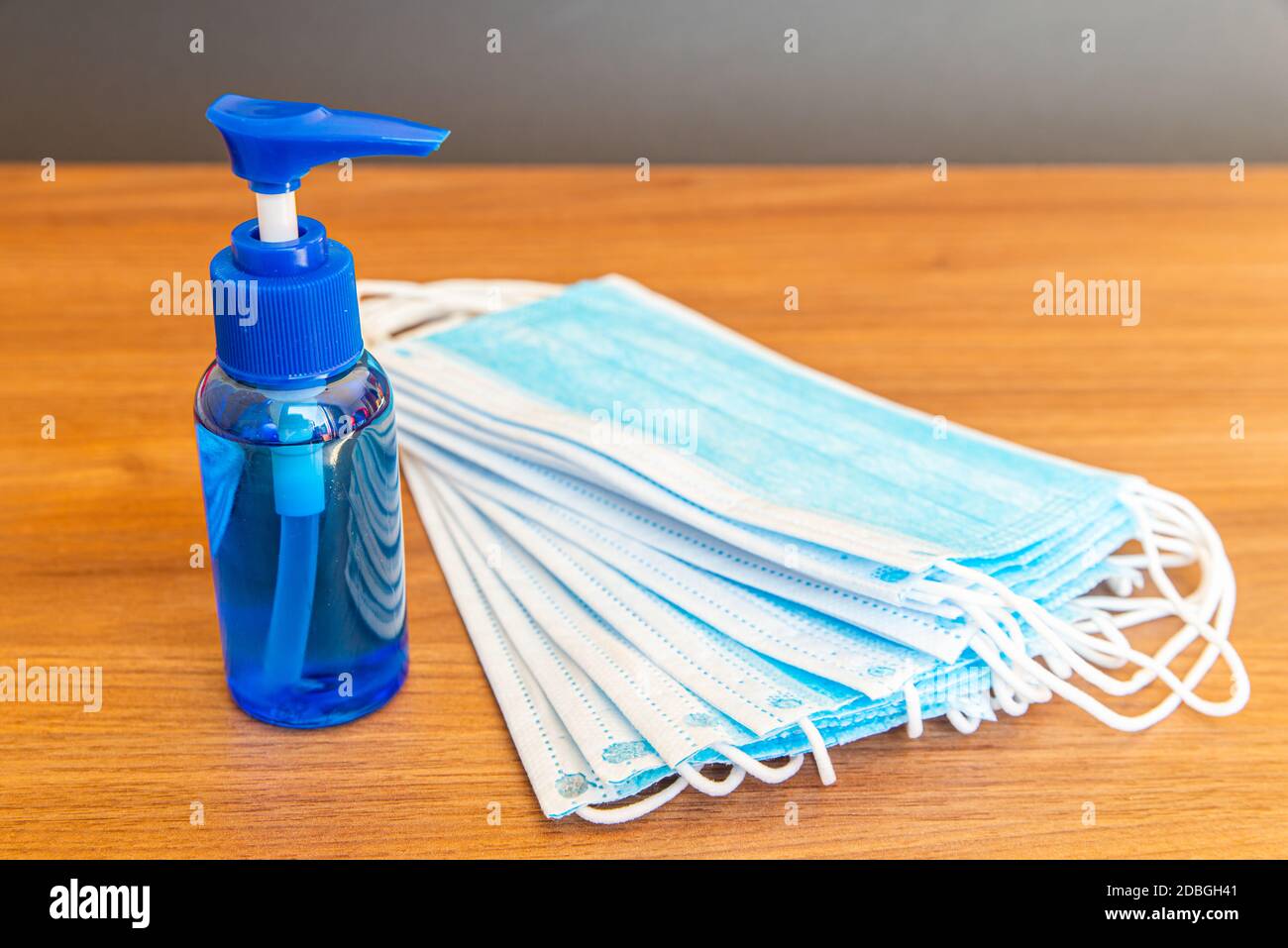 Blue surgical masks, with hand dispenser gel next to them Stock Photo ...