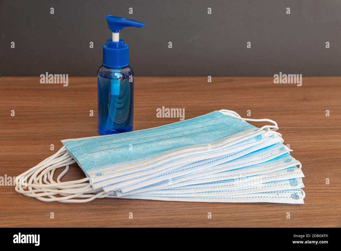 Blue surgical masks, with hand dispenser gel next to them Stock Photo ...