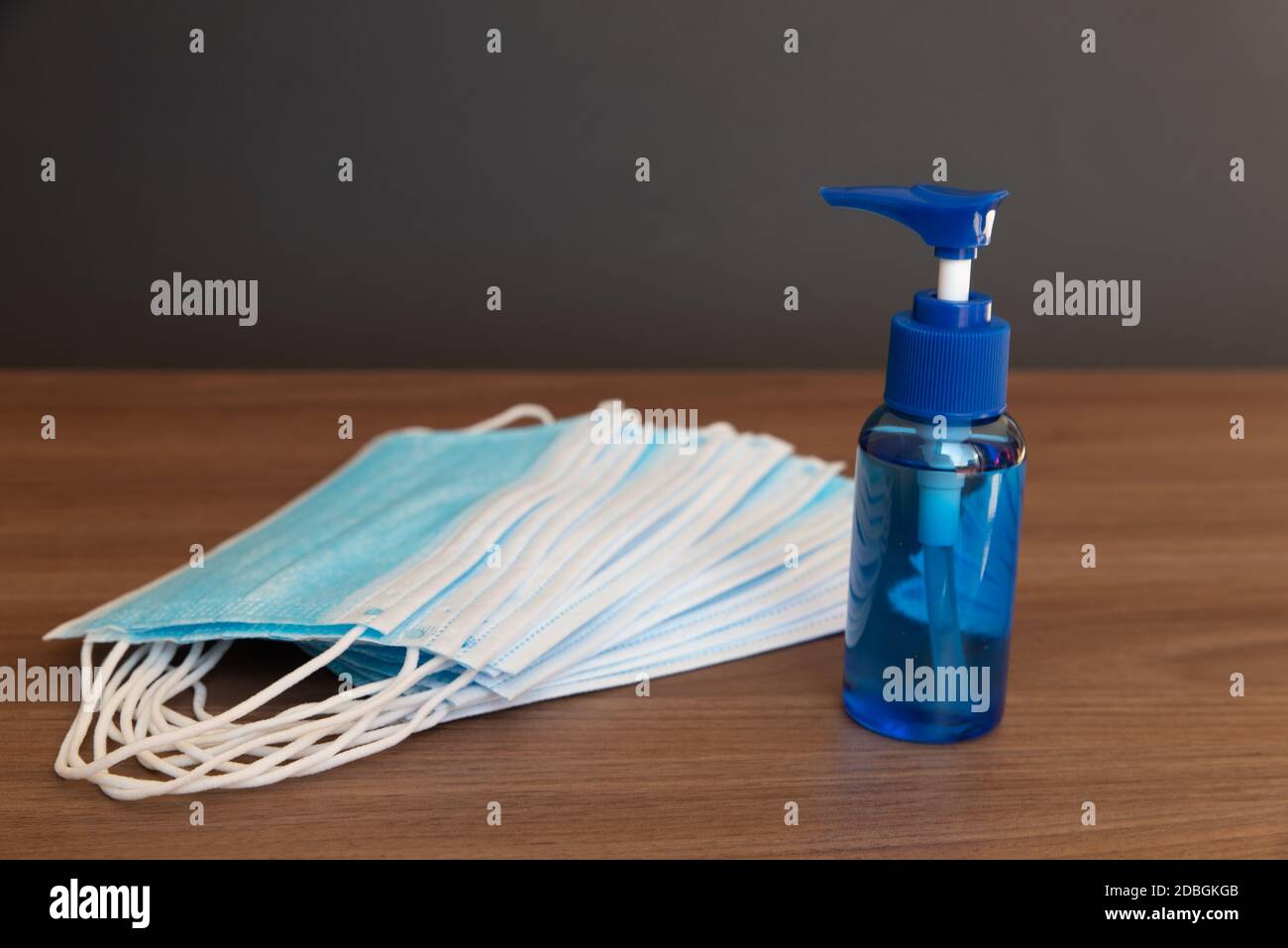 Blue surgical masks, with hand dispenser gel next to them Stock Photo ...