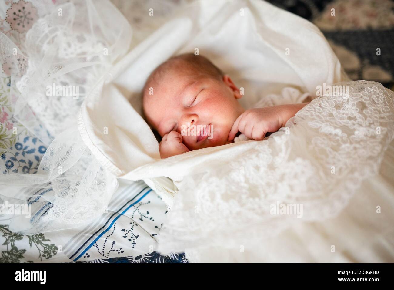 Newborn baby boy in bed. New born child in white bodykit lying in light ...
