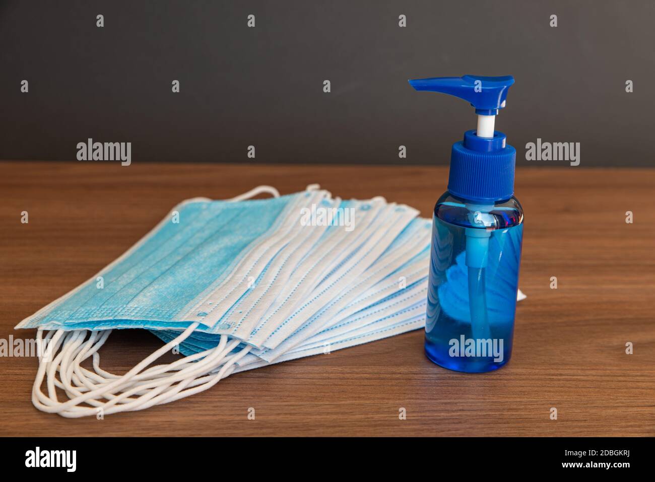 Blue surgical masks, with hand dispenser gel next to them Stock Photo ...