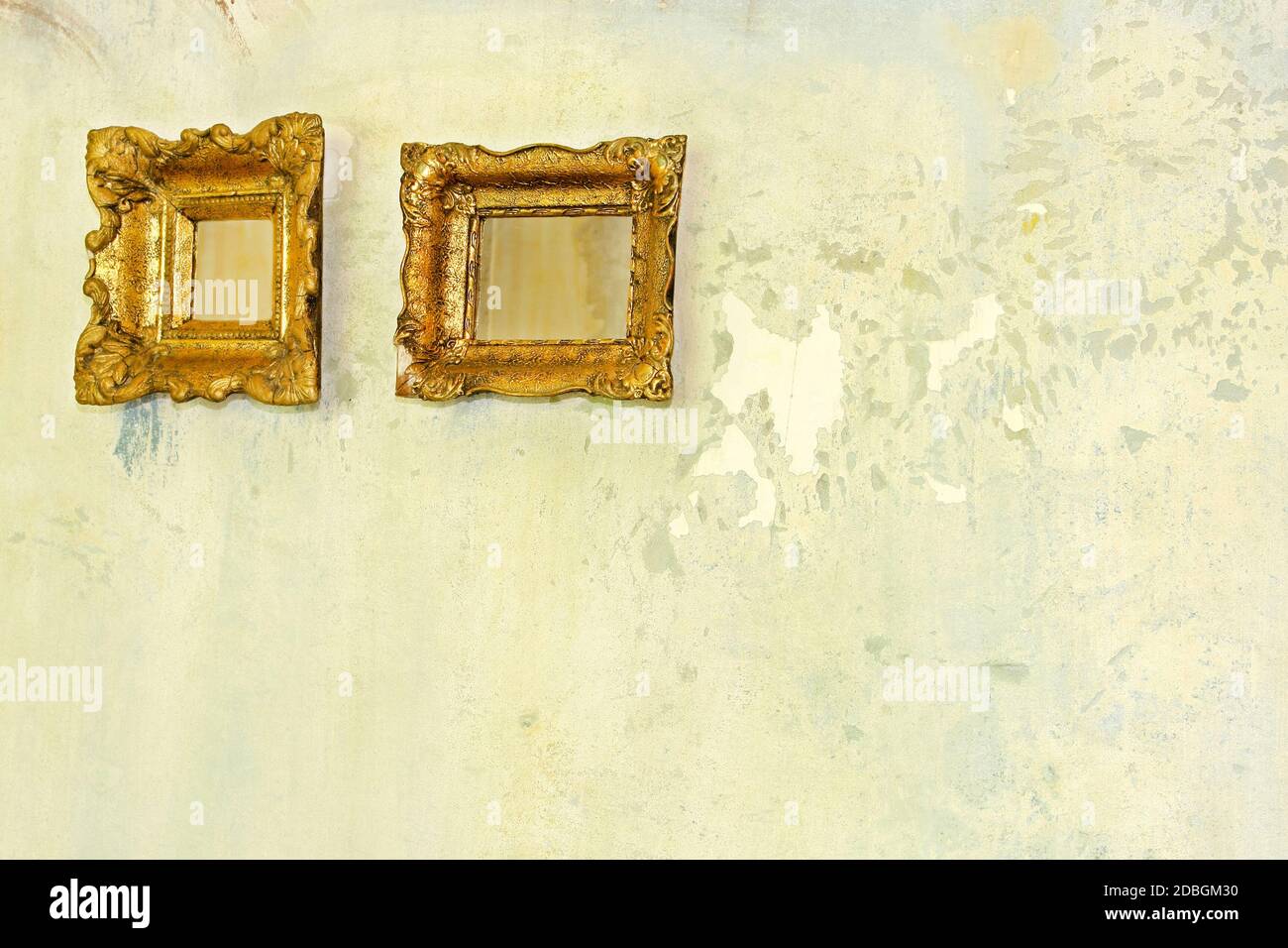 Two golden frames at grunge musty wall Stock Photo - Alamy