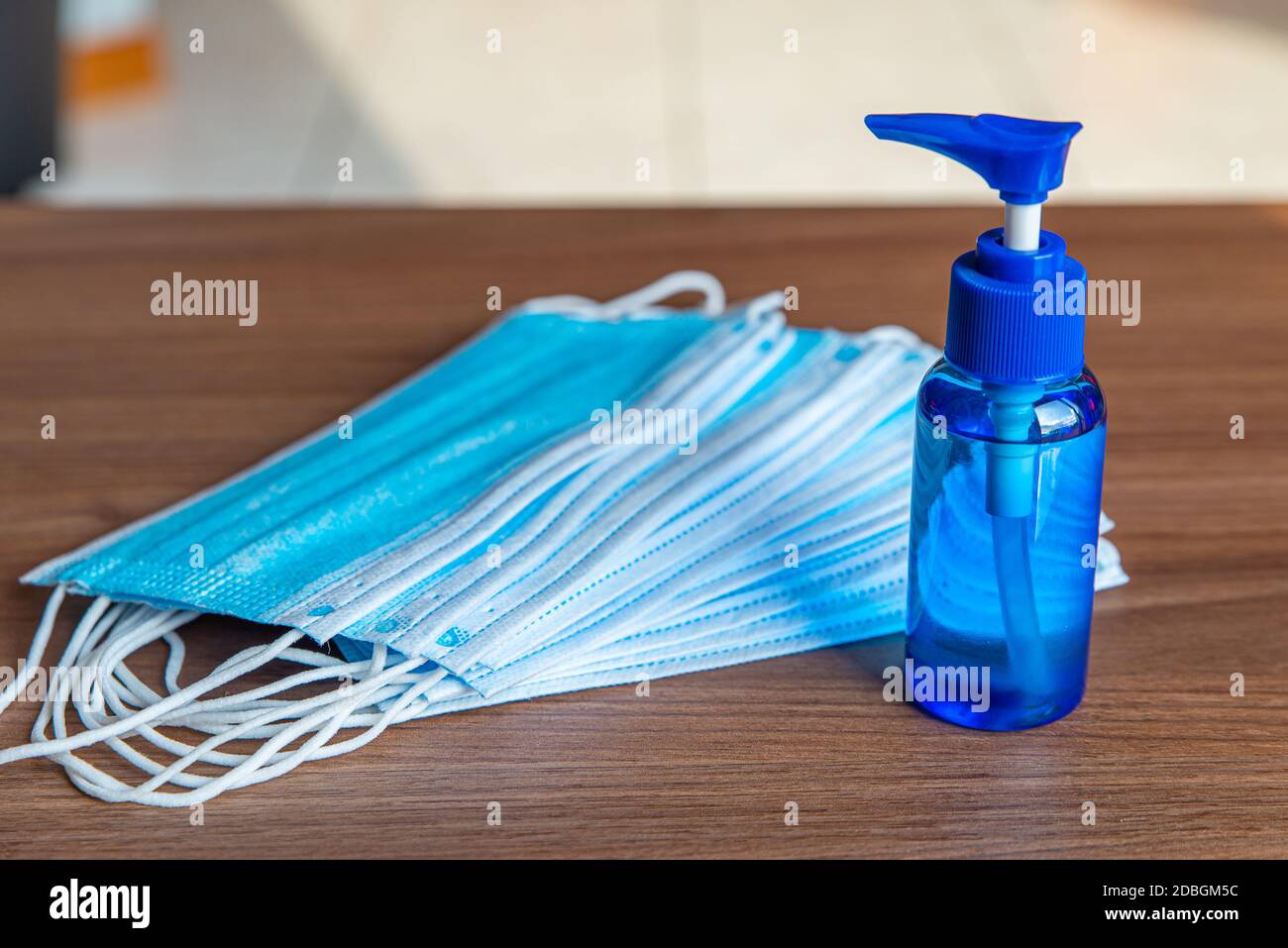 Blue surgical masks, with hand dispenser gel next to them Stock Photo ...