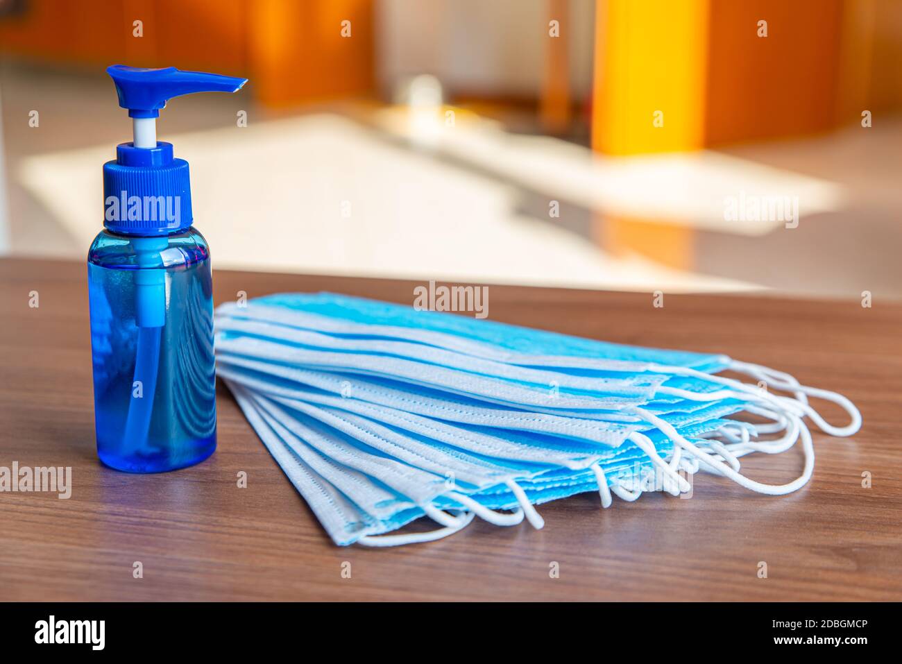 Blue surgical masks, with hand dispenser gel next to them Stock Photo ...