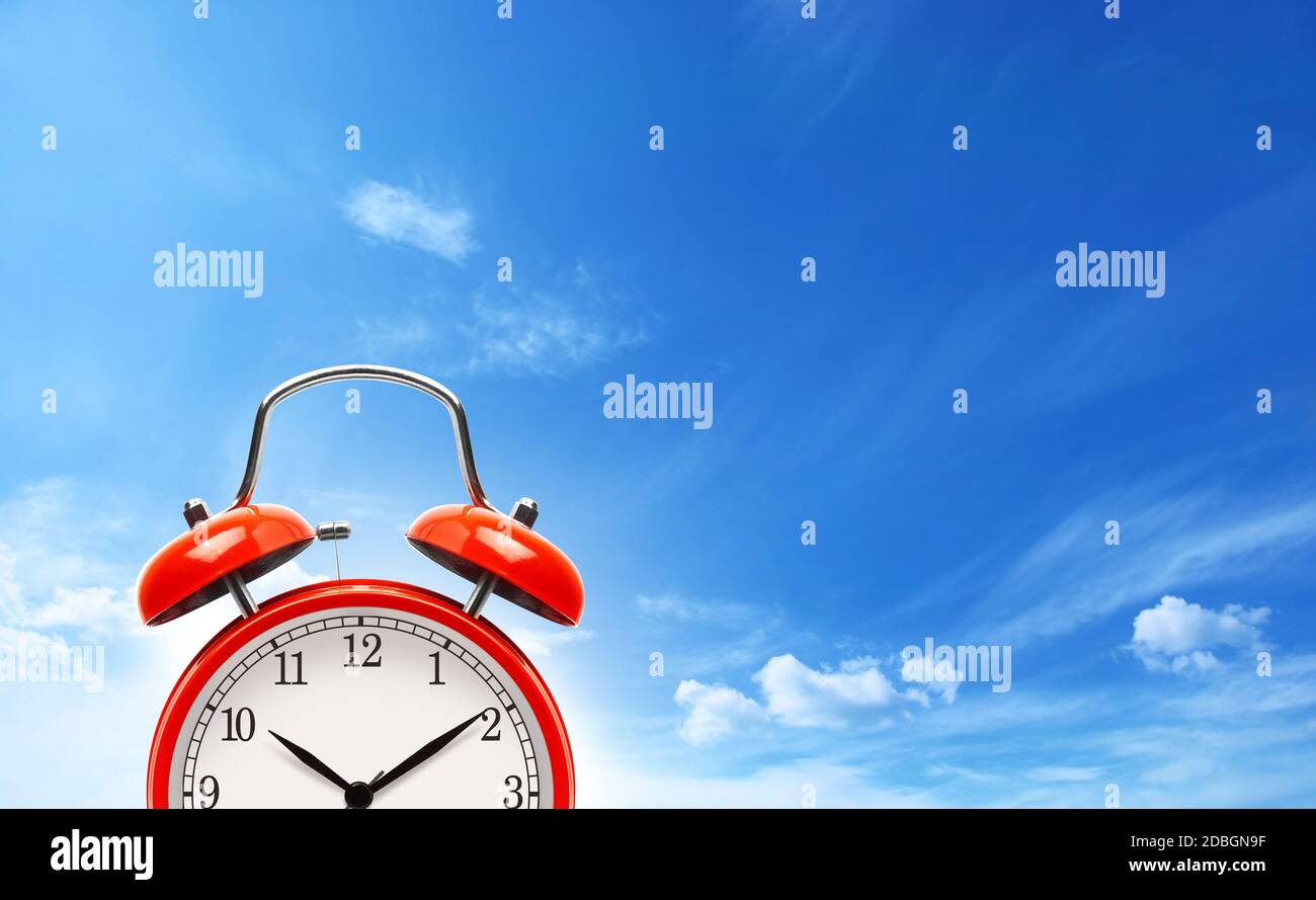 Analog red alarm clock on blue sky background with copy space Stock ...