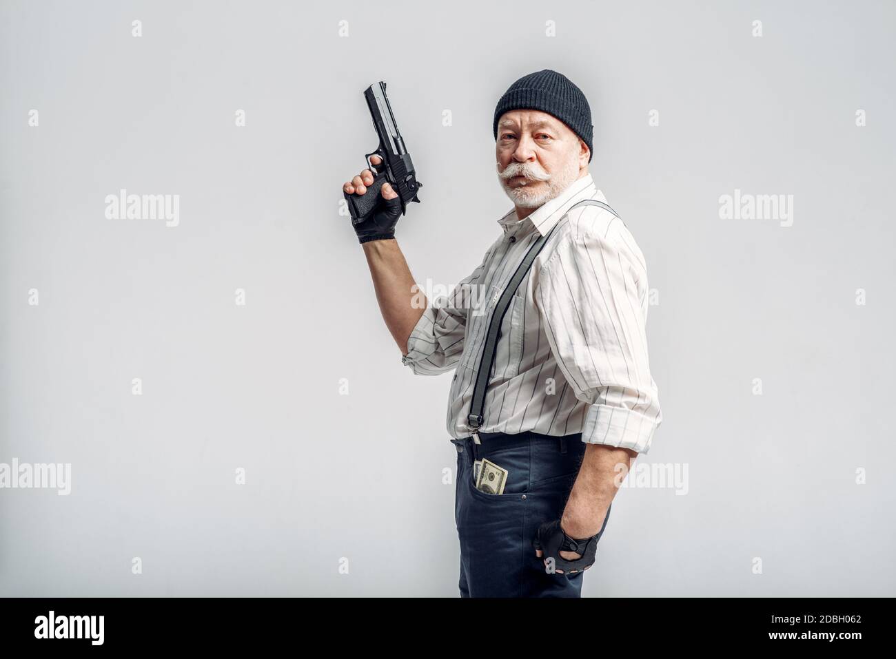 Elderly man with gun isolated on grey background, gangster. Mature ...