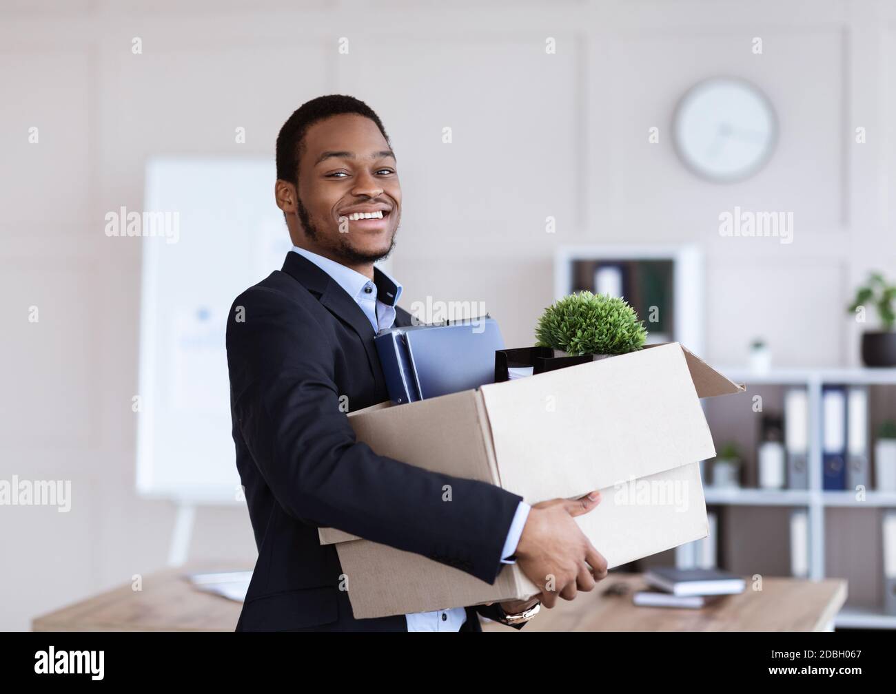 Happy black businessman moving office with box and his belongings Stock ...
