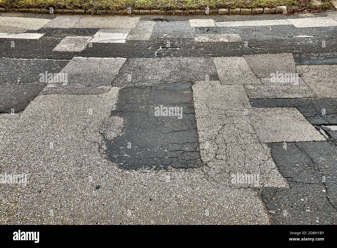 Extremely bad quality road with many patches, potholes Stock Photo - Alamy