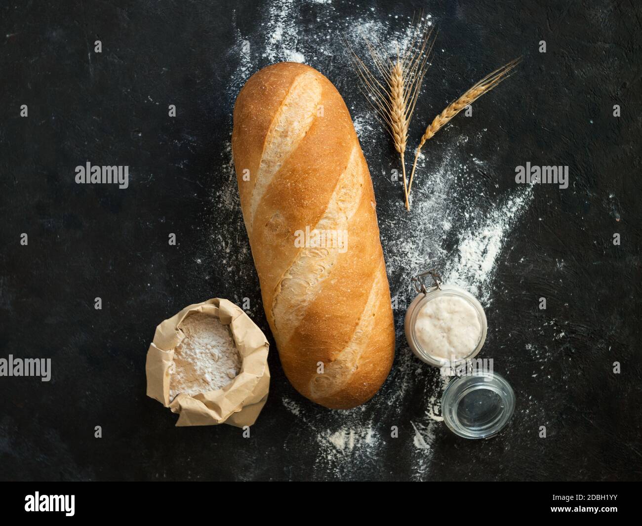 British White Bloomer or European sourdough Baton loaf bread on black ...