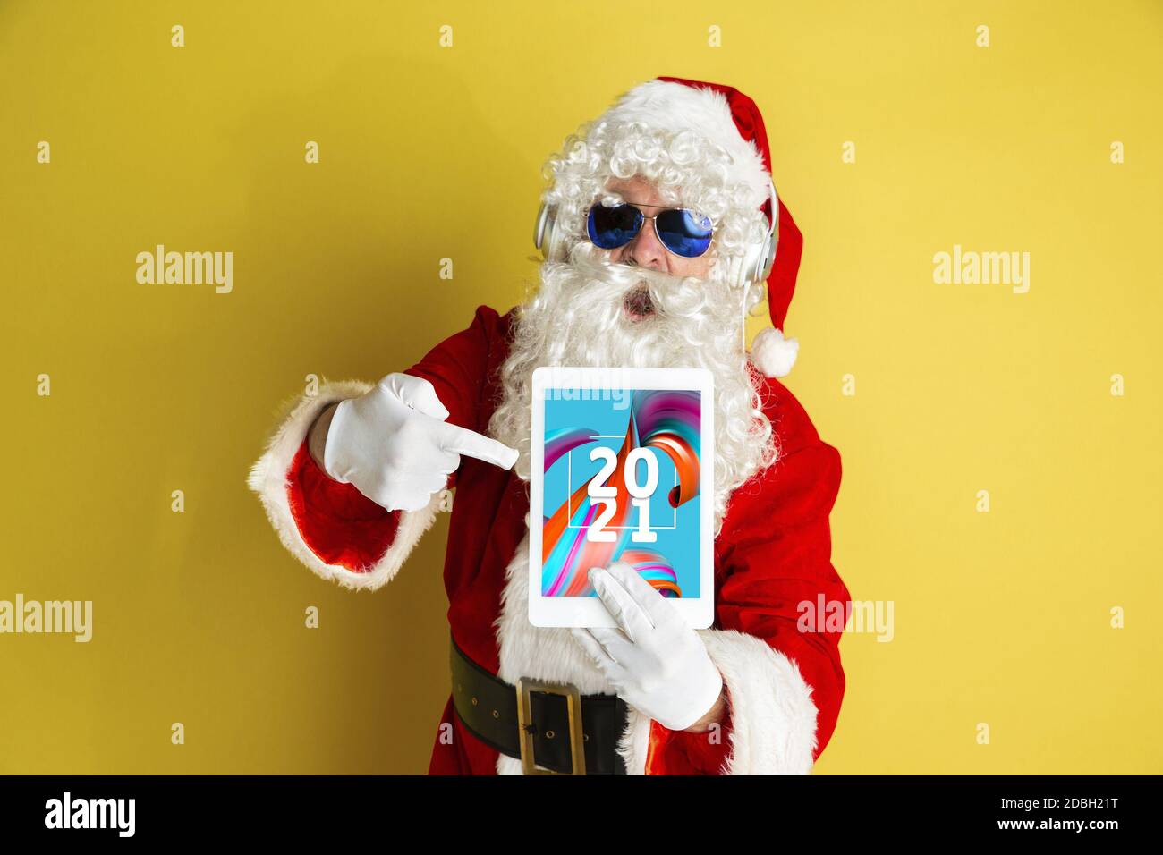 Stylish Santa Claus in traditional costume with modern device pointing ...