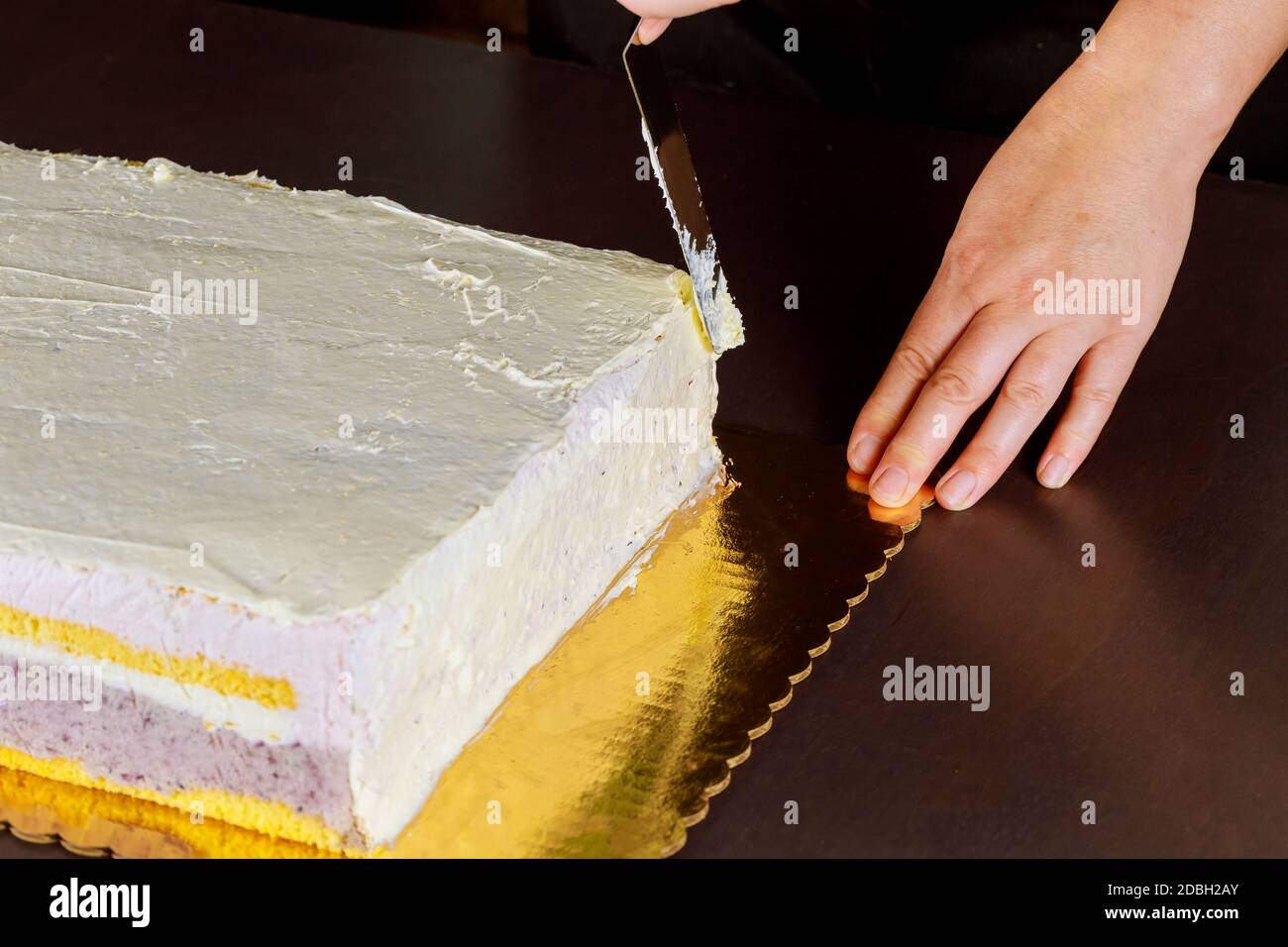 Chef cover with white icing festive cake. Making layer sponge cake ...