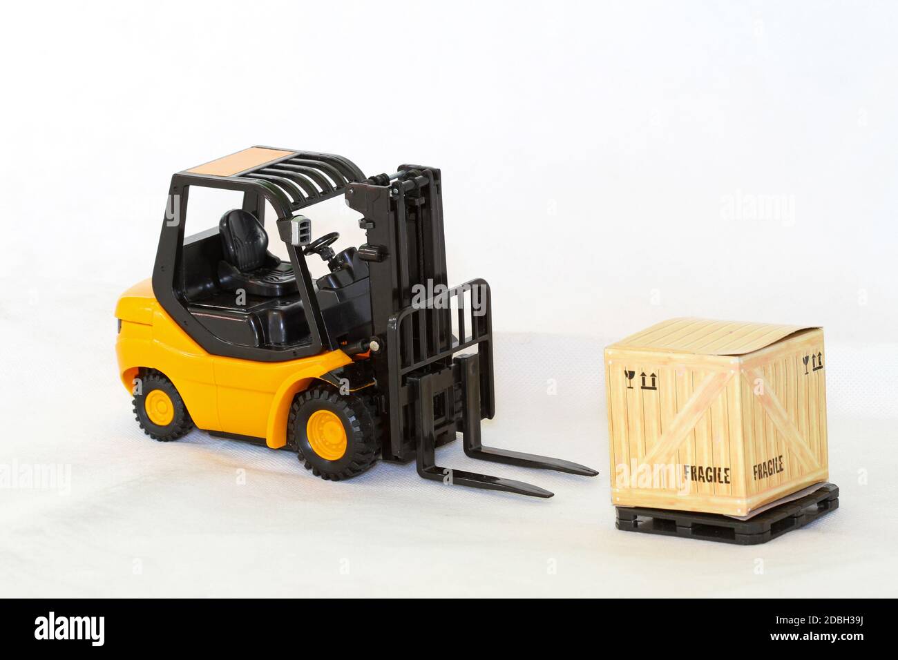 Miniature model of forklift with crate at pallet Stock Photo - Alamy