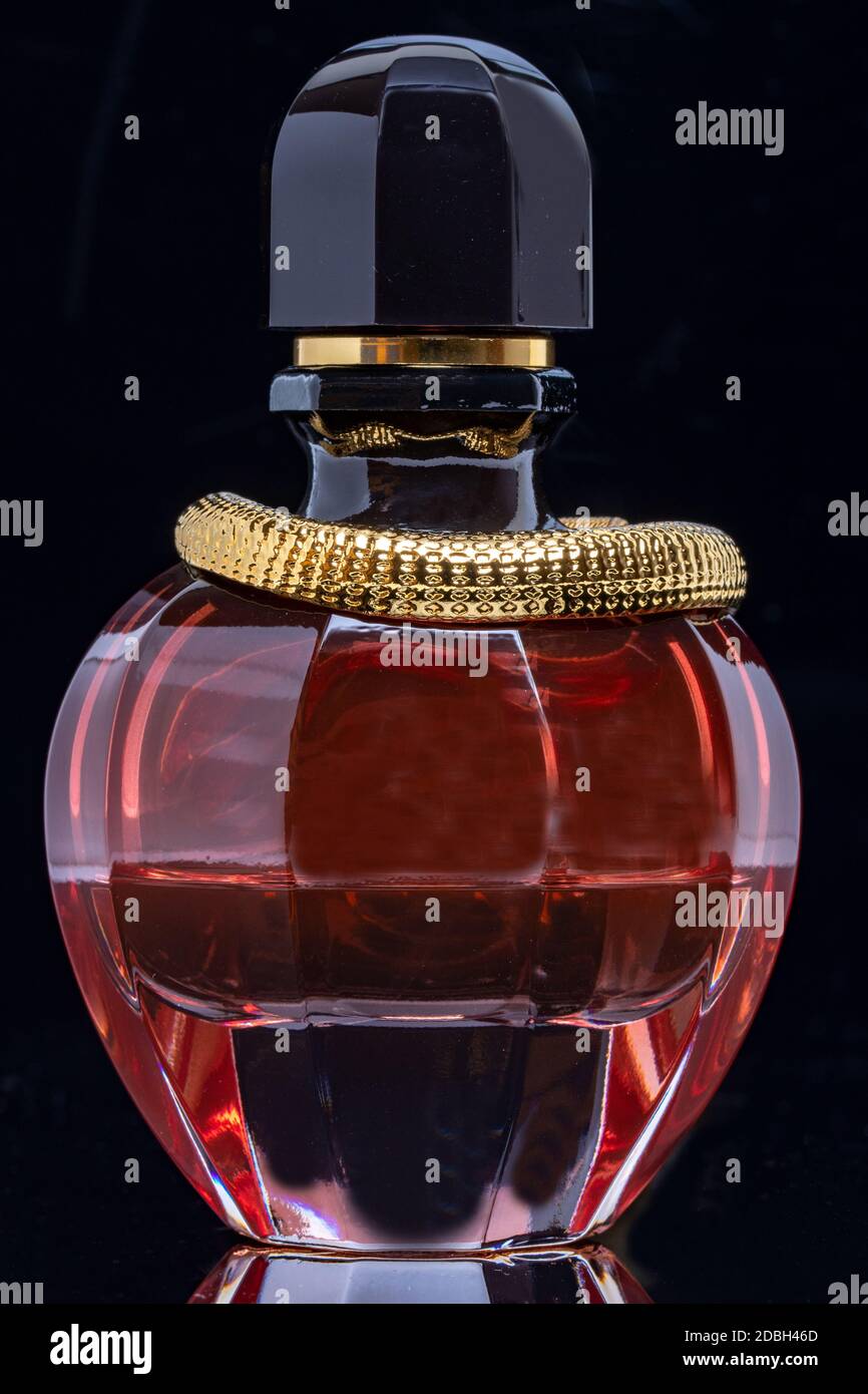 Luxurious perfume in red beautiful glass bottle with gold decorations ...