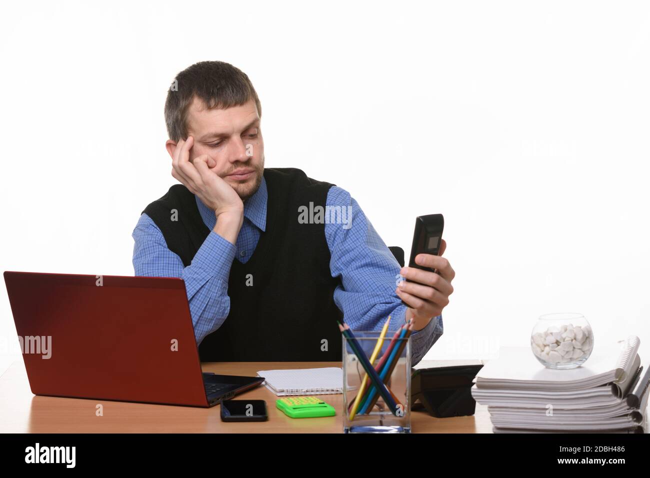 Office worker dials number on phone sitting at desk Stock Photo - Alamy