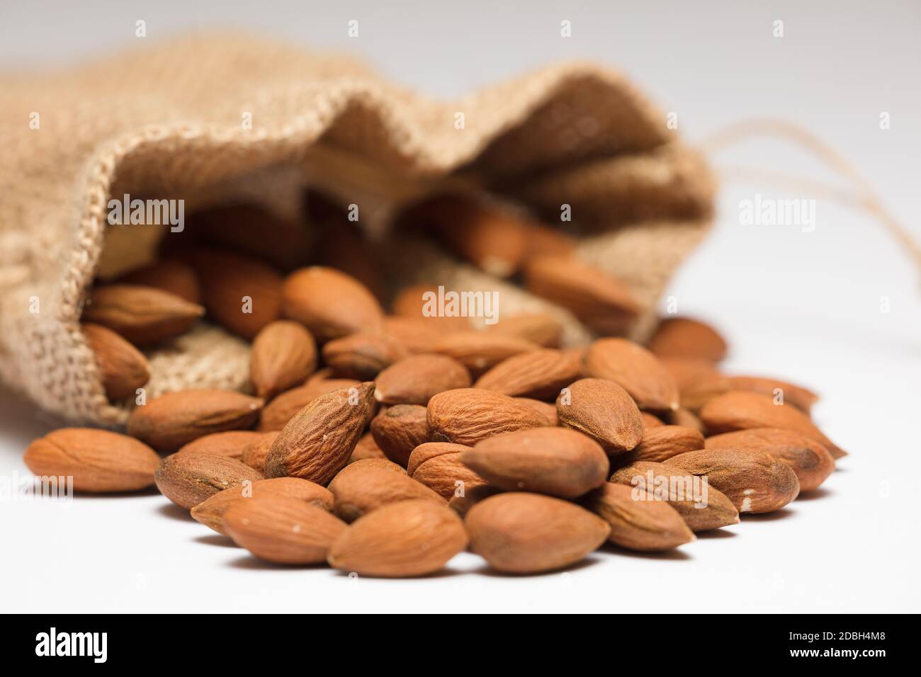 raffia sack with group of almonds isolated, with white background Stock ...