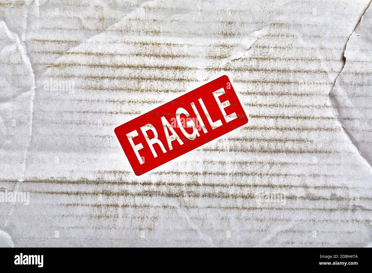 Fragile stamp on a delivery pack slightly broken Stock Photo - Alamy