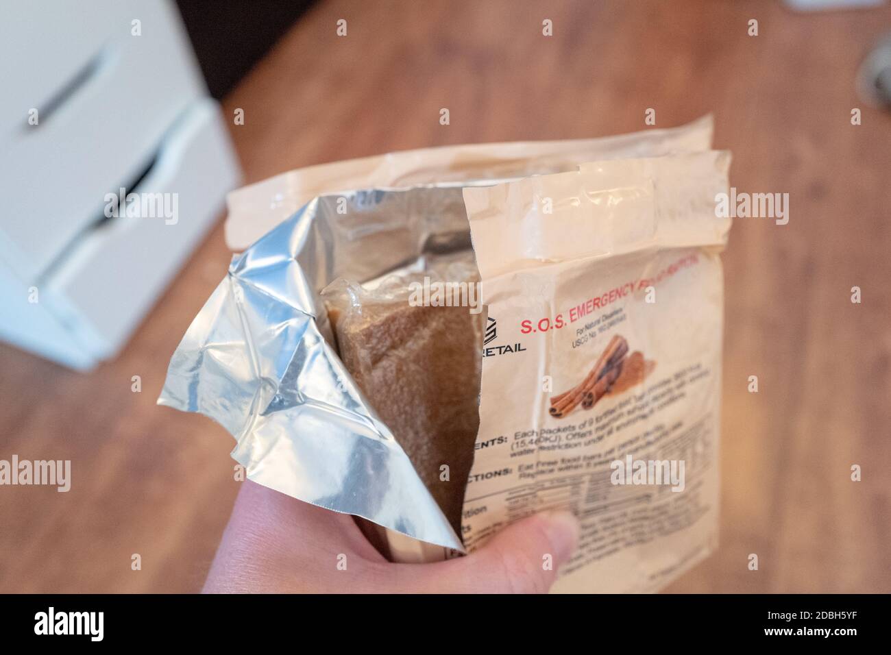 Person holding an opened pack of S.O.S. Rations Emergency Cinnamon ...