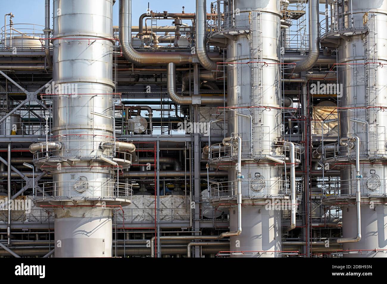 Close-up of pipelines and destillation tanks of an oil-refinery plant ...