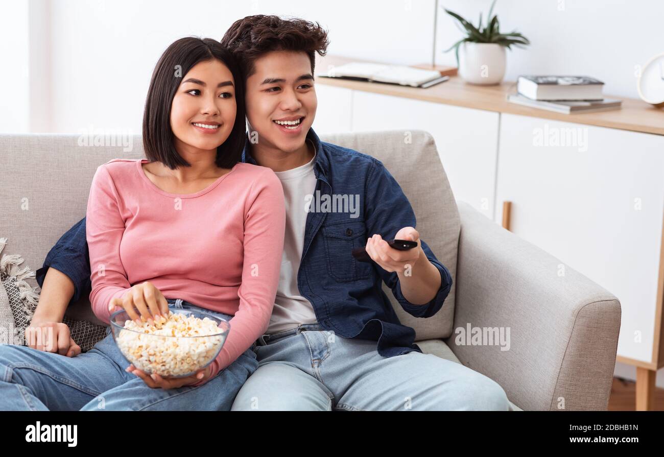 Chinese Family Couple Watching TV Together In Living Room Stock Photo ...