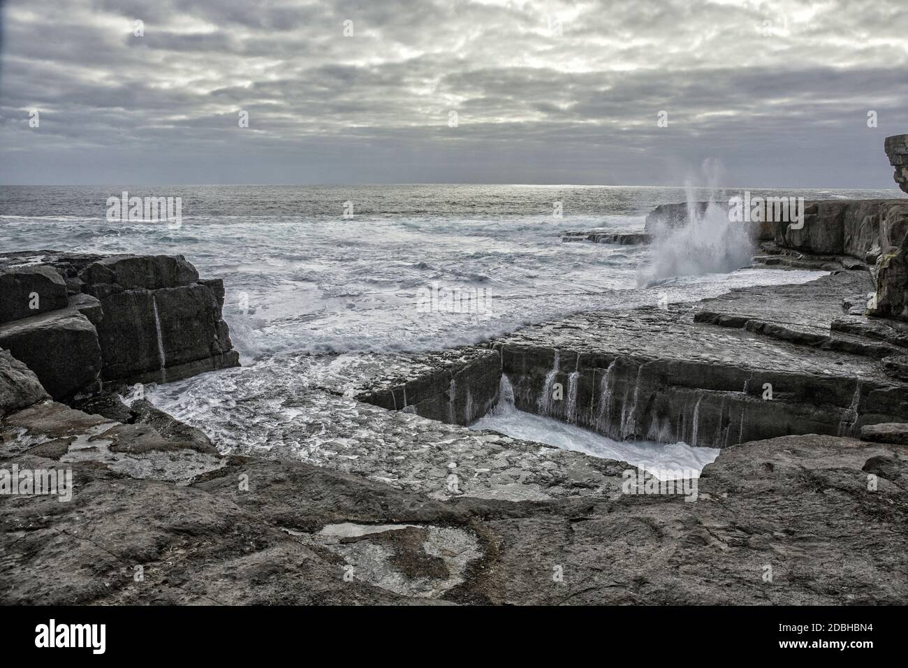 Sea cliffs hole in the rock named The Wormhole on Aran Islands, Ireland ...