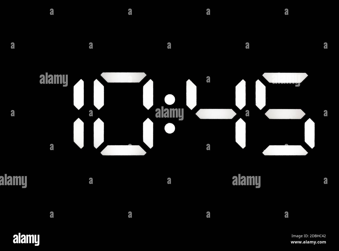 Real white led digital clock on a black background showing time 10:45 ...