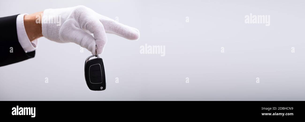Valet's Hand Holding Car Key Against White Background Stock Photo - Alamy