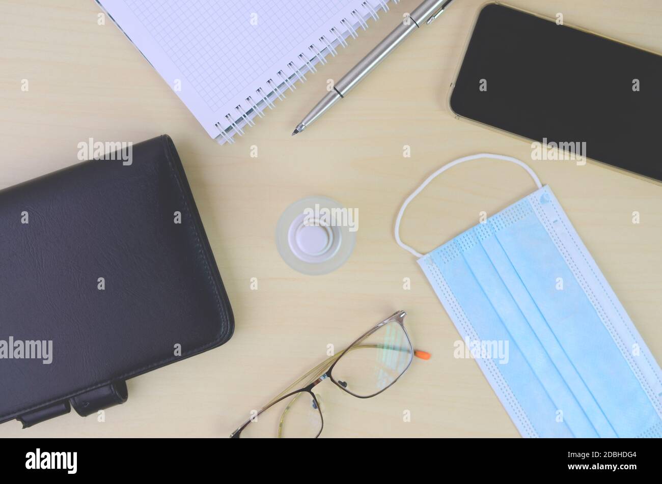 Office desk table with face mask and sanitizer bottle or alcohol gel ...