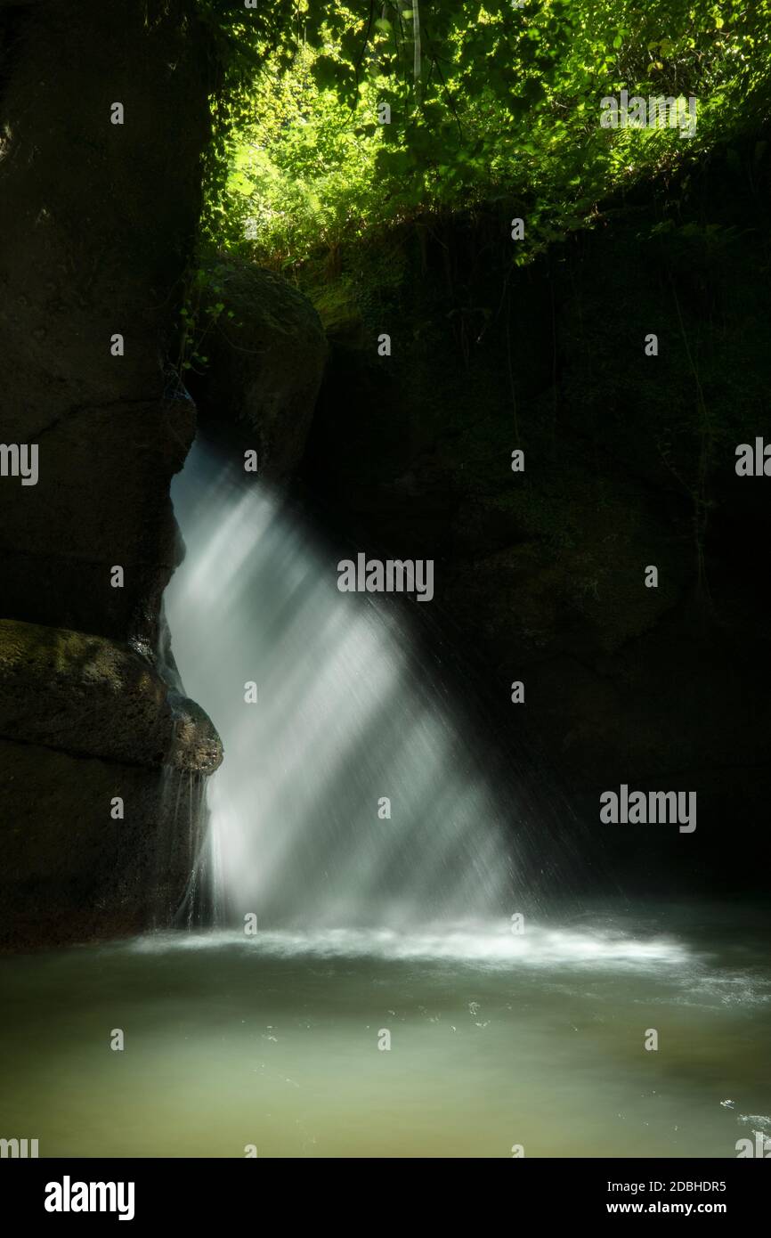 Waterfall with rays of light Stock Photo - Alamy