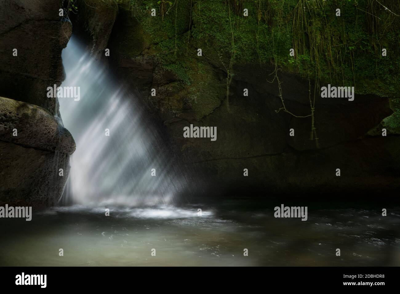 Waterfall with rays of light Stock Photo - Alamy