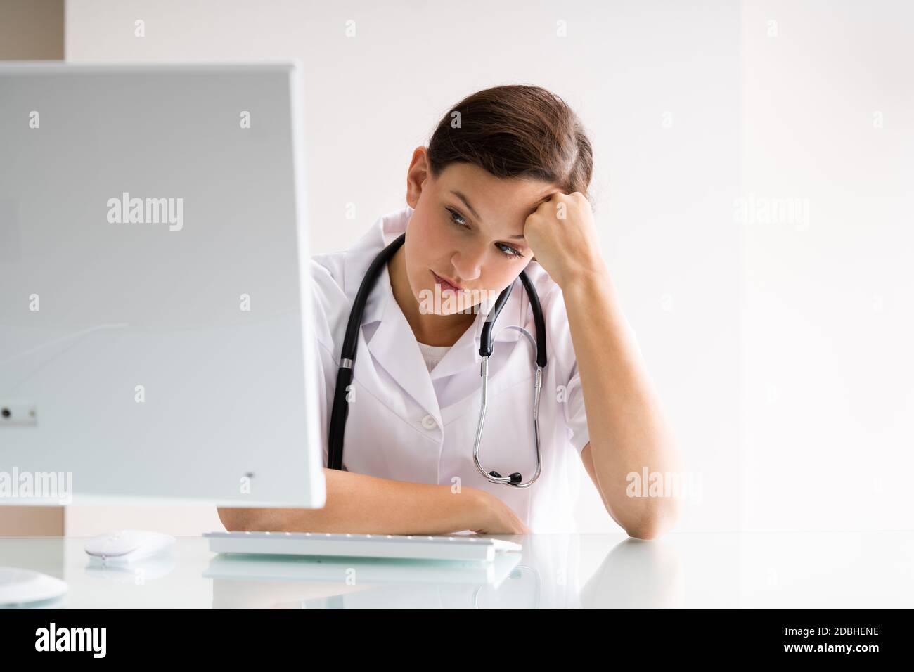 Frustrated Overworked Sad Doctor At Computer In Hospital Stock Photo ...