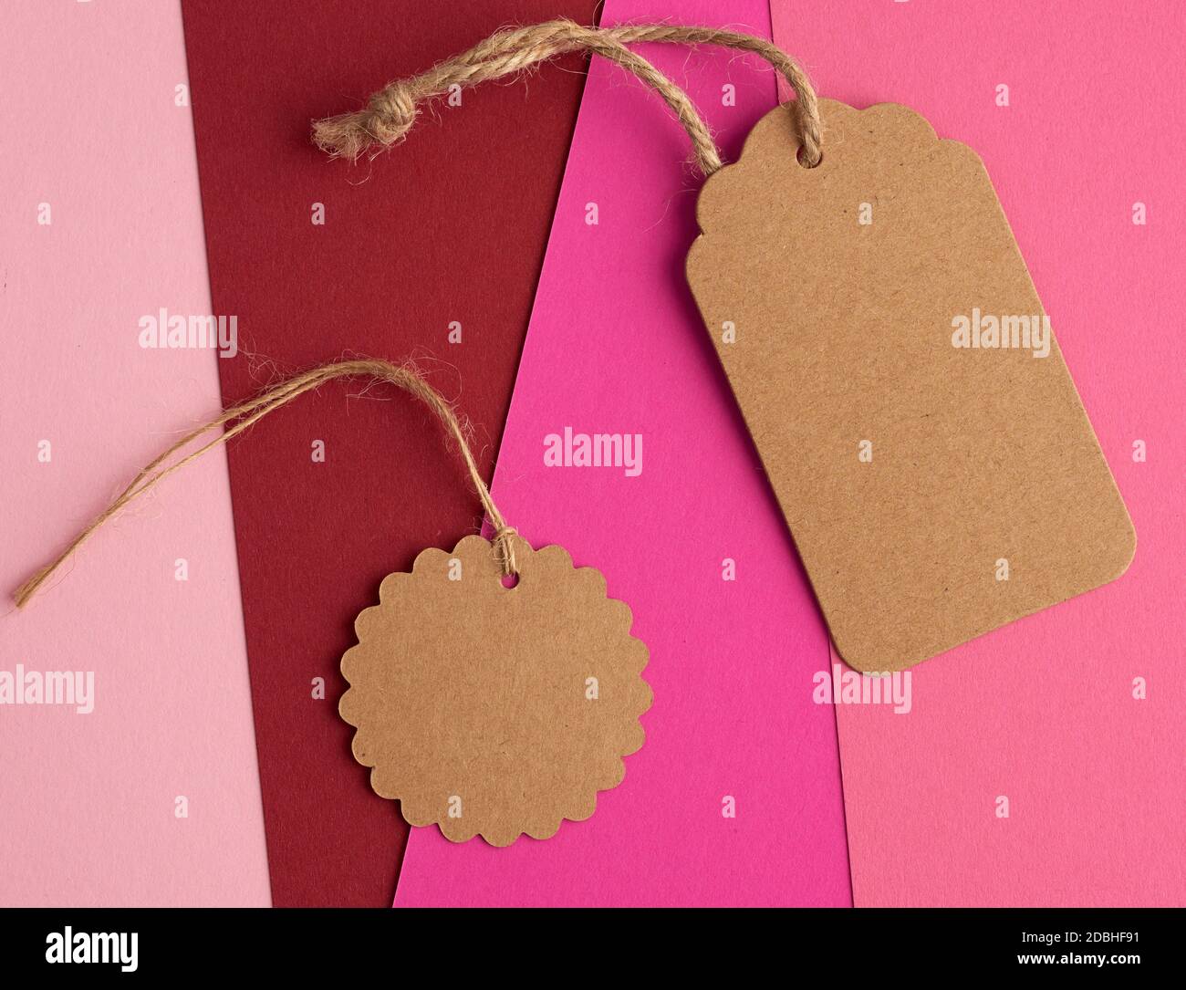 paper brown round and rectangular price tag on a rope on a colored ...