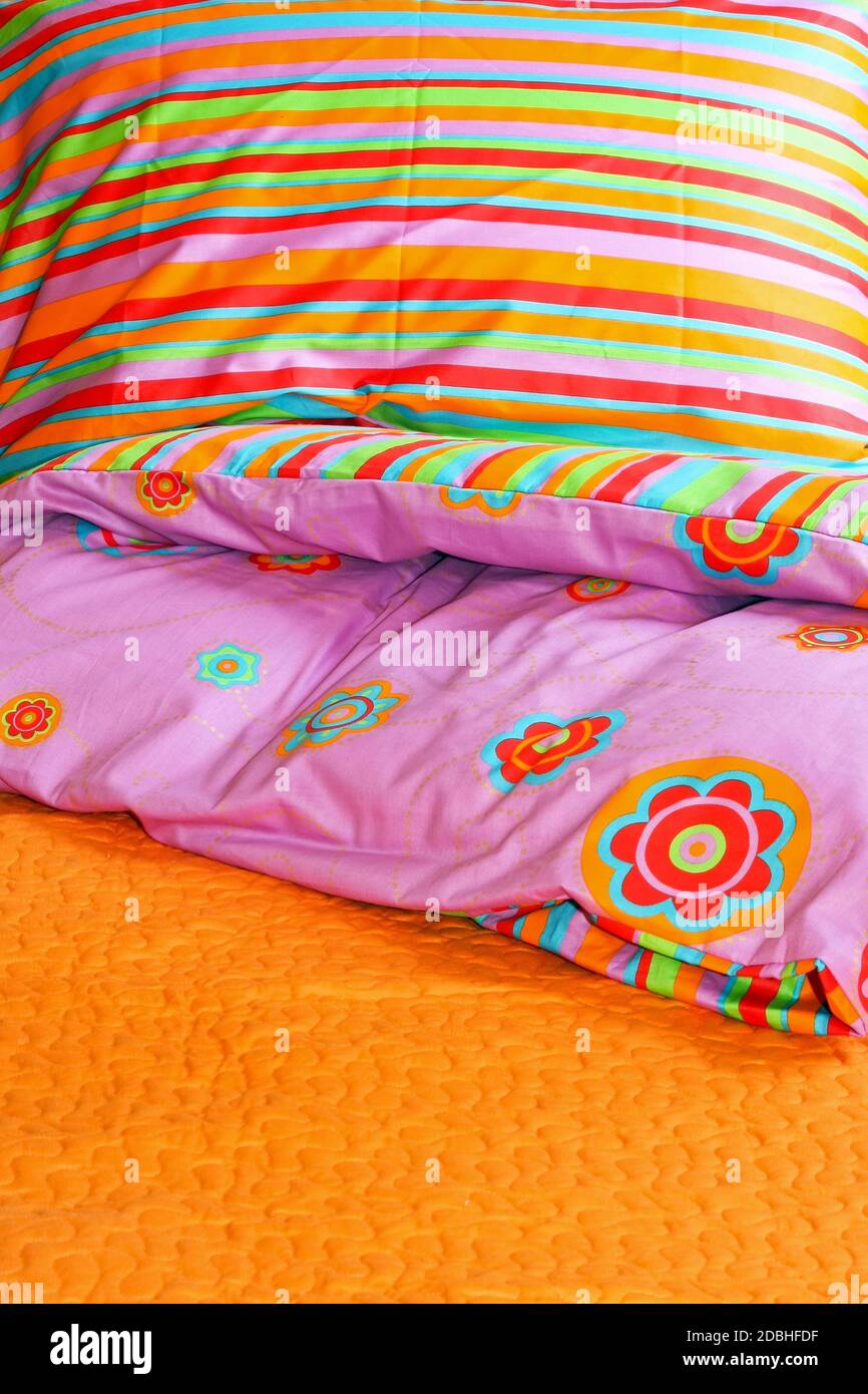 Bunch of pillows and colorful sheets over bed Stock Photo - Alamy