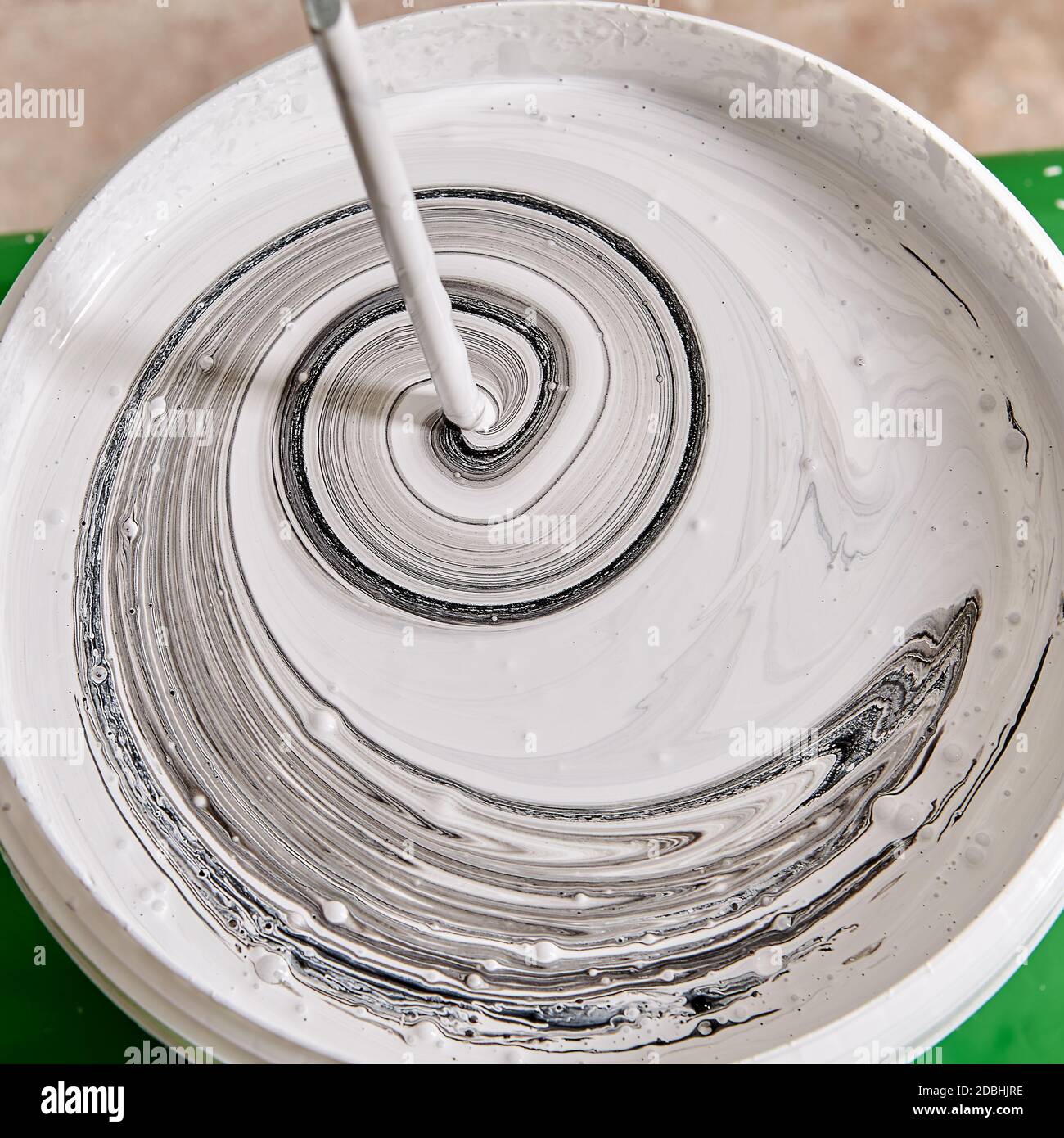 Home painter is mixing various colors in the basket with help of drill ...