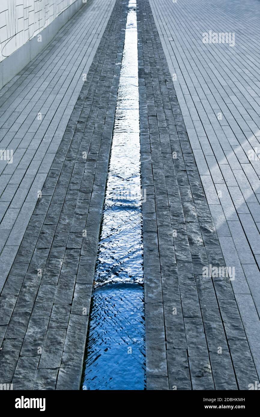 Modern street pavement with blue water way Stock Photo - Alamy
