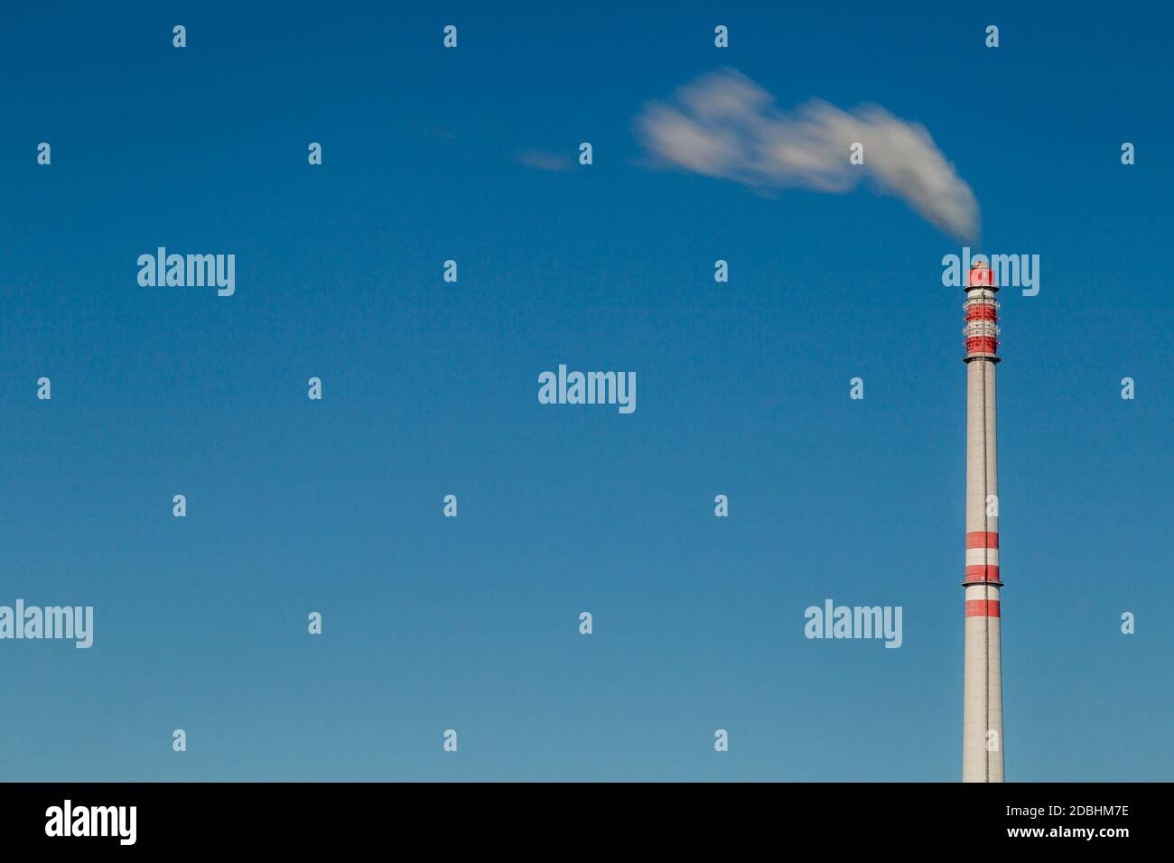 Industrial smokestack in wind. Dirty smoke from red and white factory ...