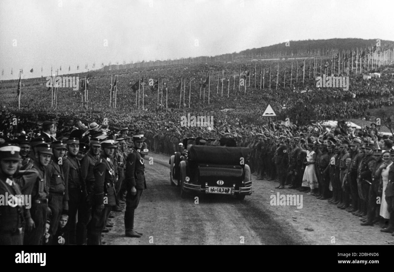 Adolf Hitler arrives in a convertible at the mass event on the ...