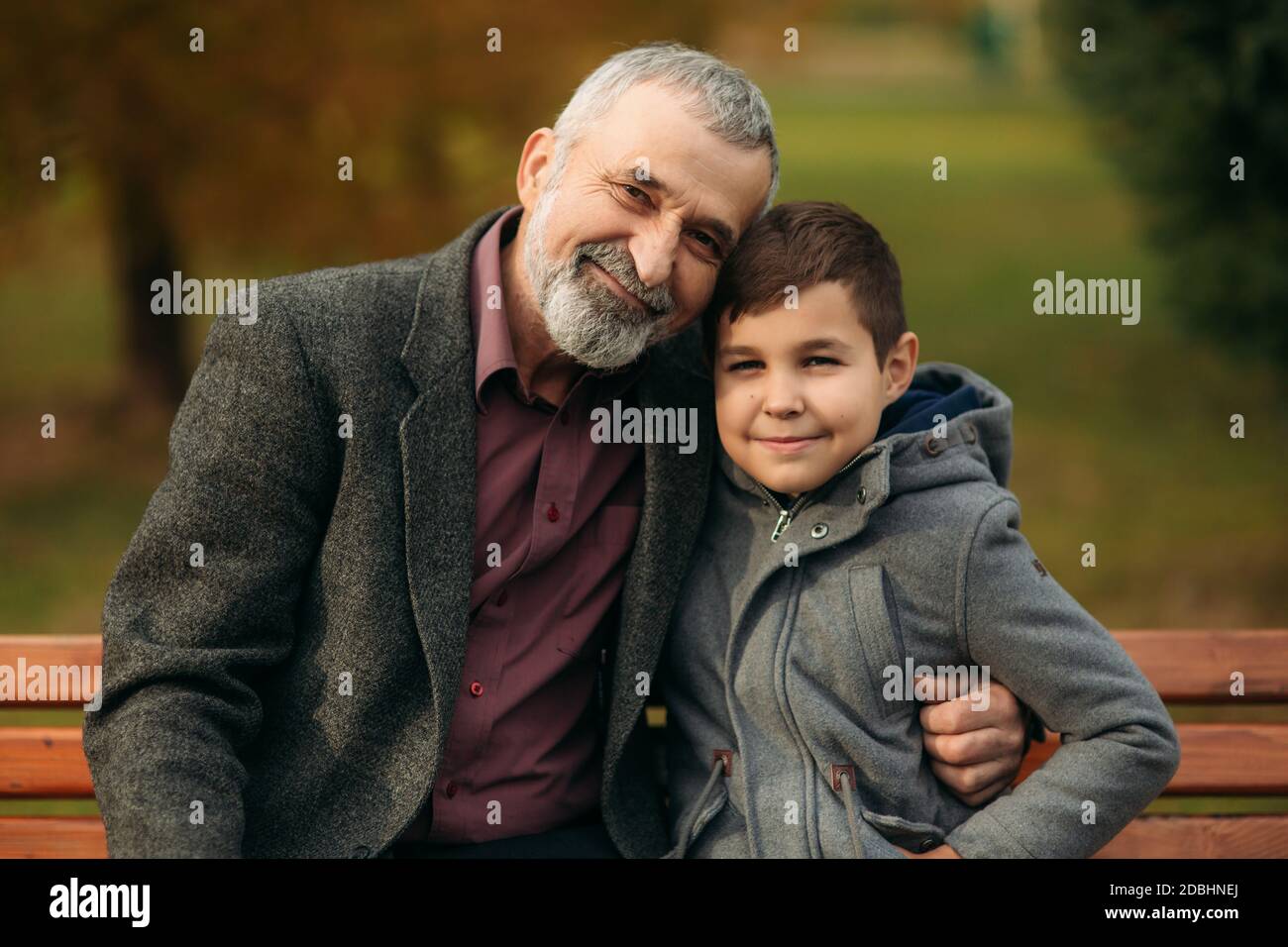 Grandpa and his grandson spend time together in the park. They are ...