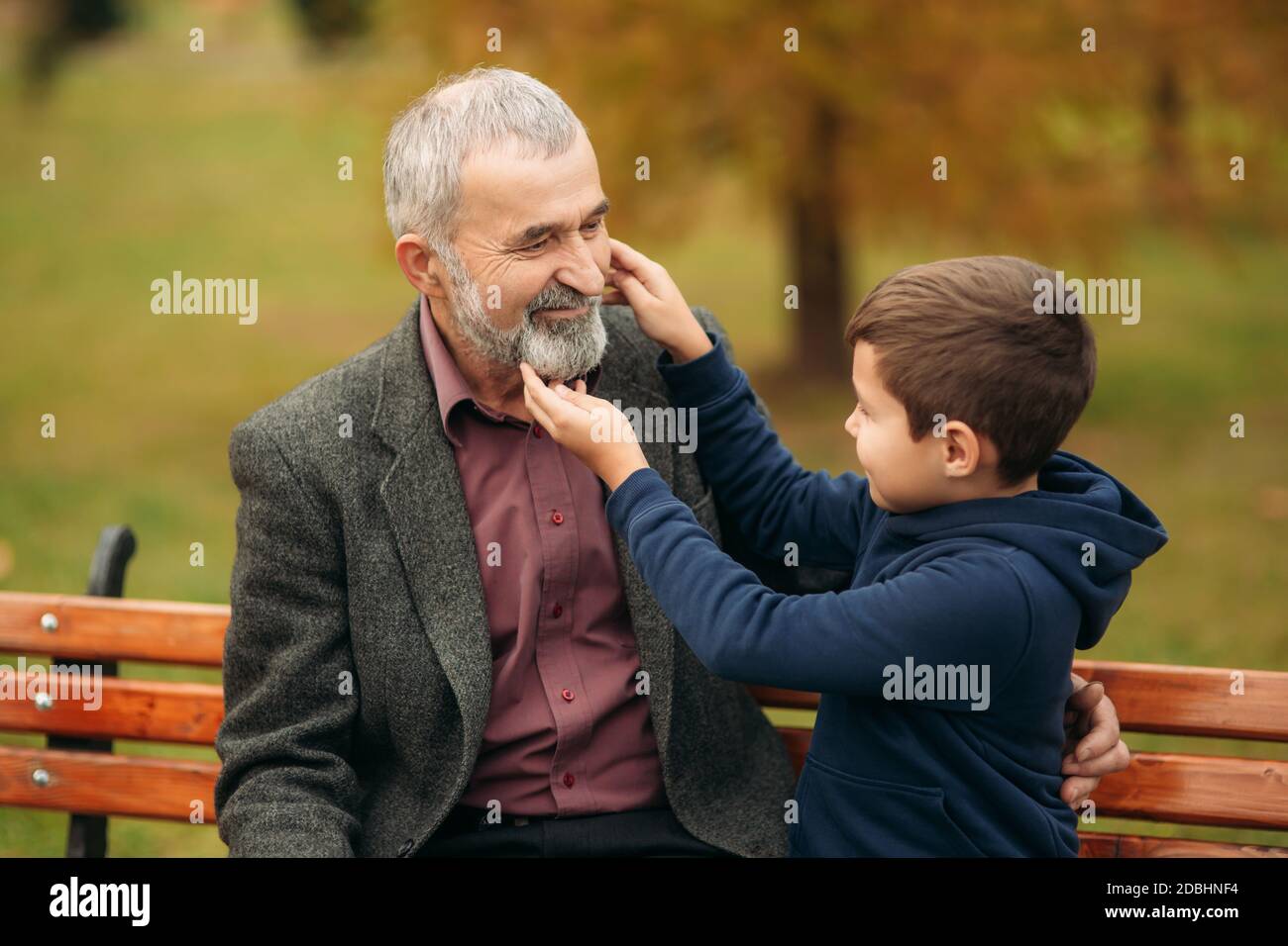 Grandpa and his grandson spend time together in the park. They are ...