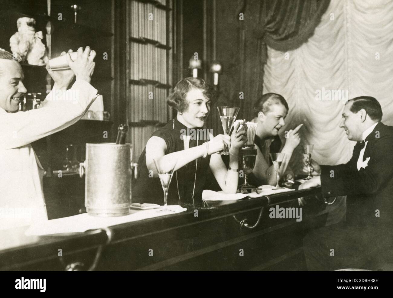 The photograph shows a bar in Berlin in 1926, the bartender is making a ...