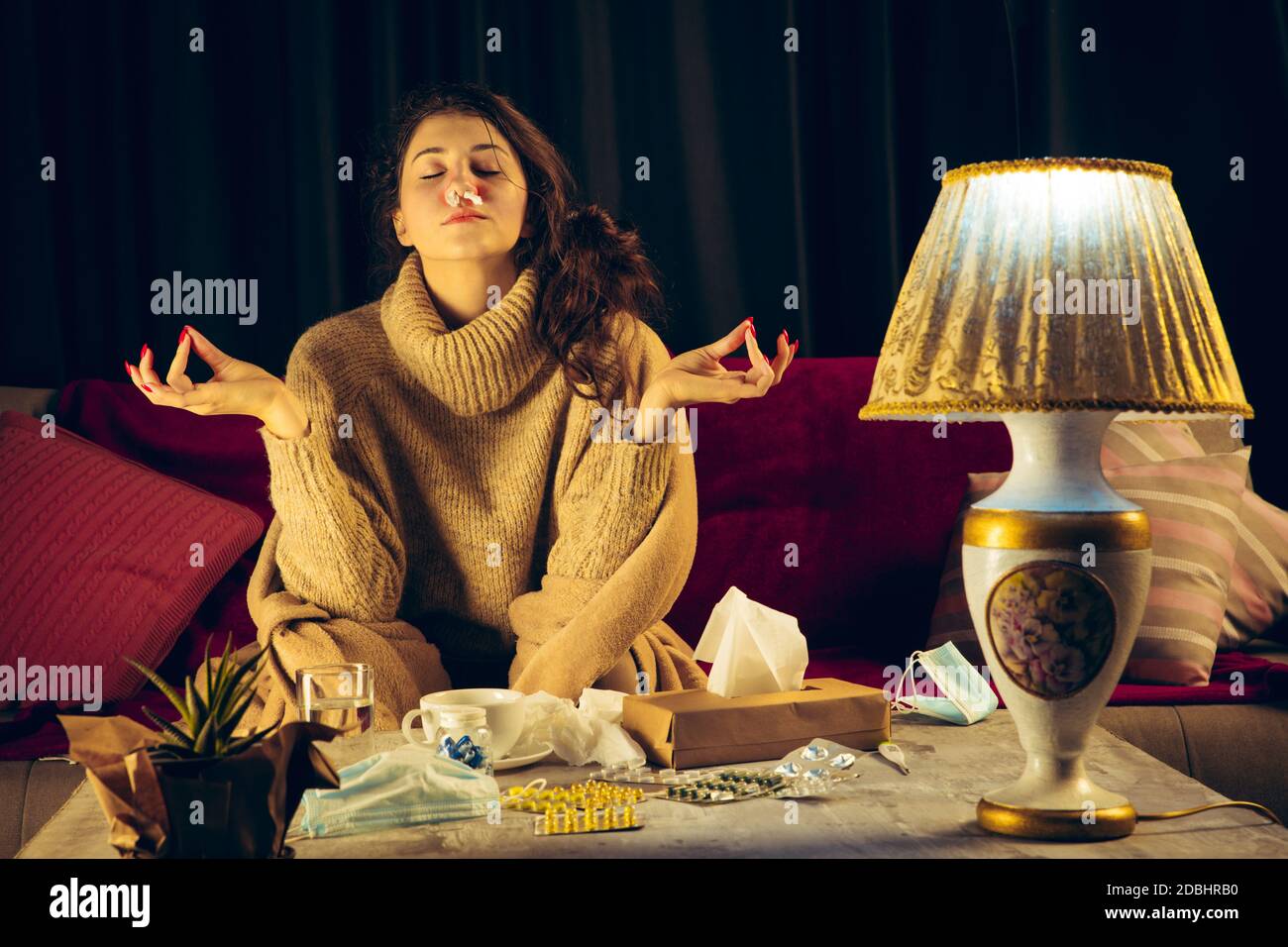 Rainy nose. Young woman wrapped in a plaid looks sick, ill, sneezing ...