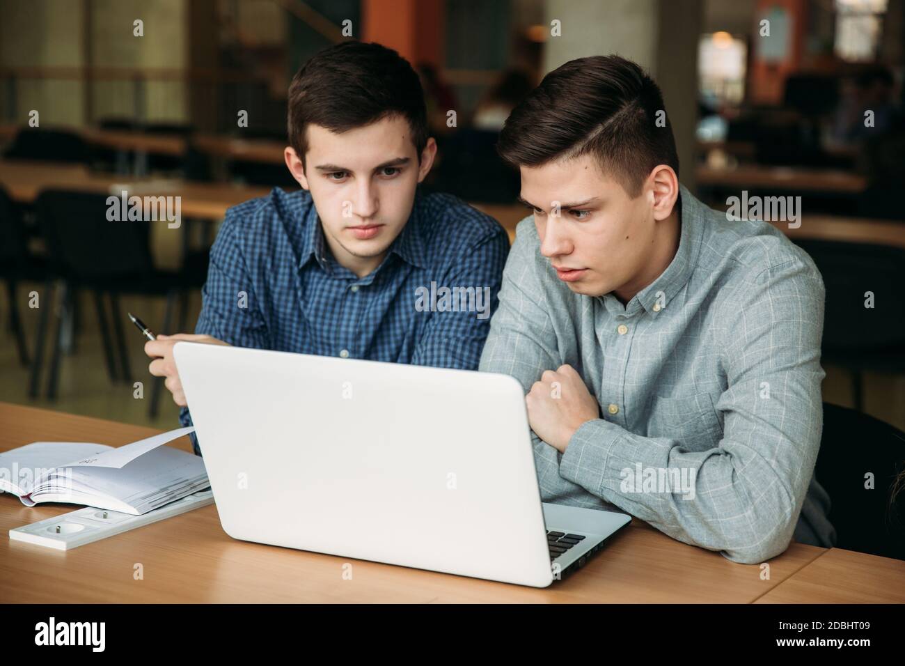 Two boy student use laptop in library Stock Photo - Alamy