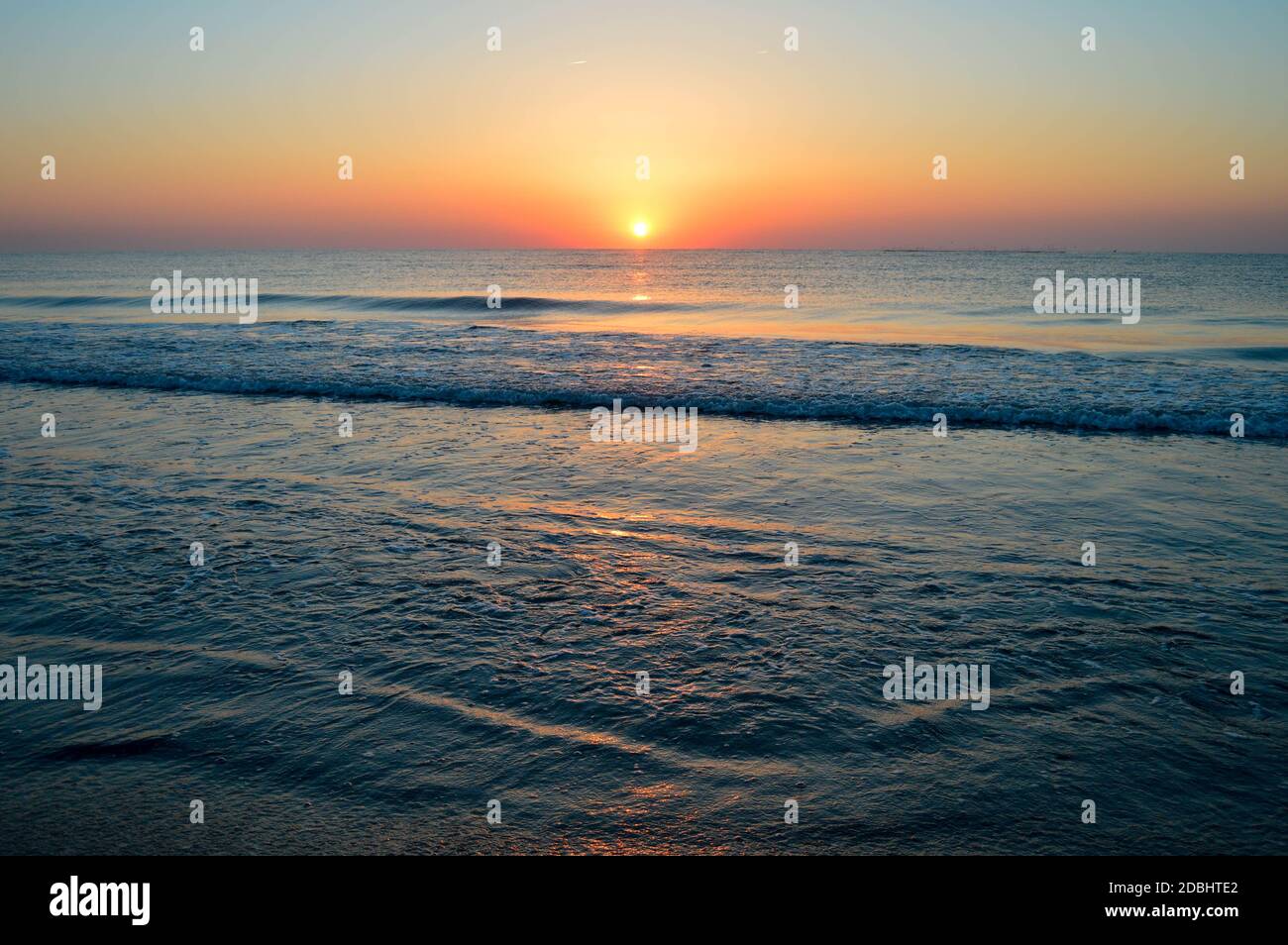 Beautiful summer landscape, sunset at the beach, sparkly sand and waves ...