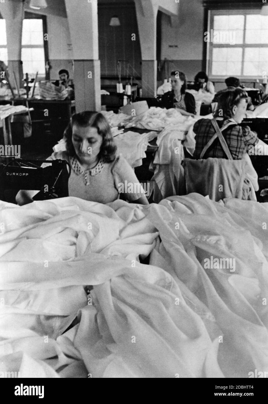 Female workers in the sewing shop of a parachute manufacturer. Their ...
