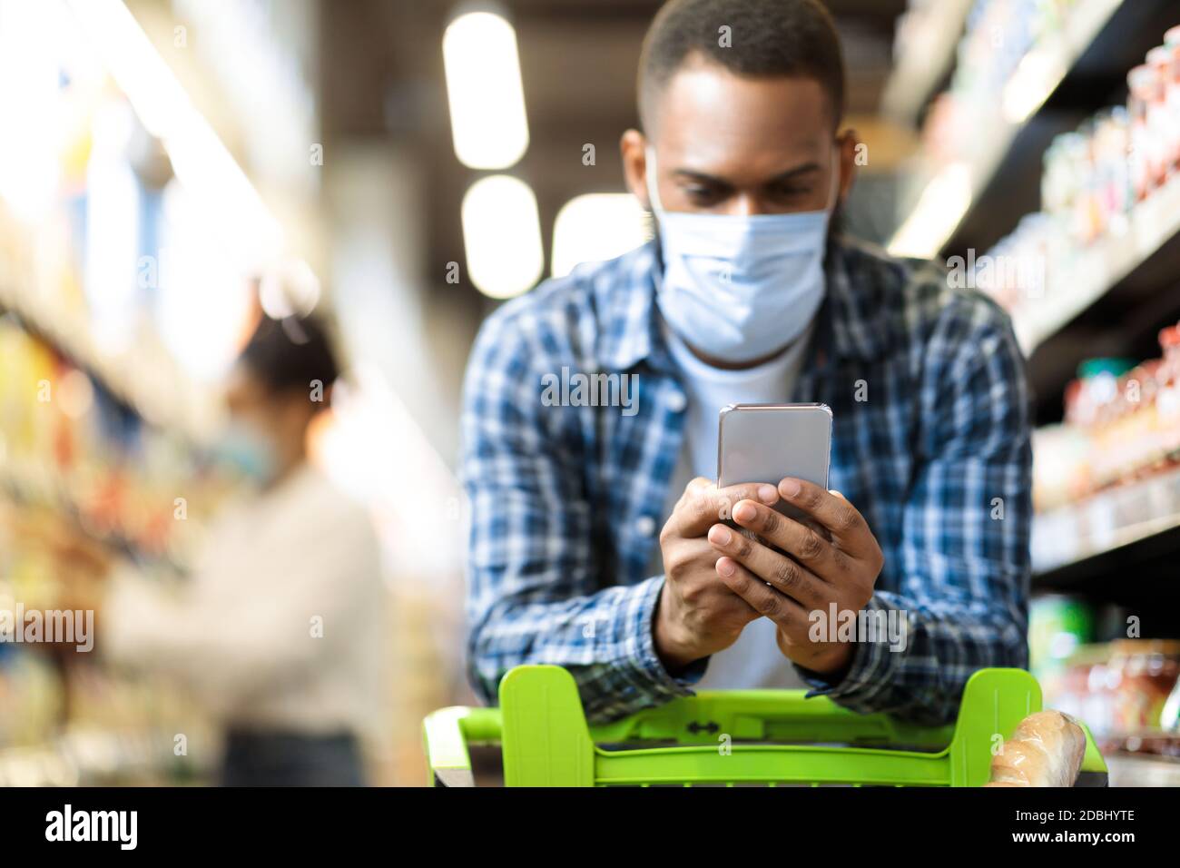 Black Man With Smartphone Shopping Food In Supermarket Wearing Mask ...