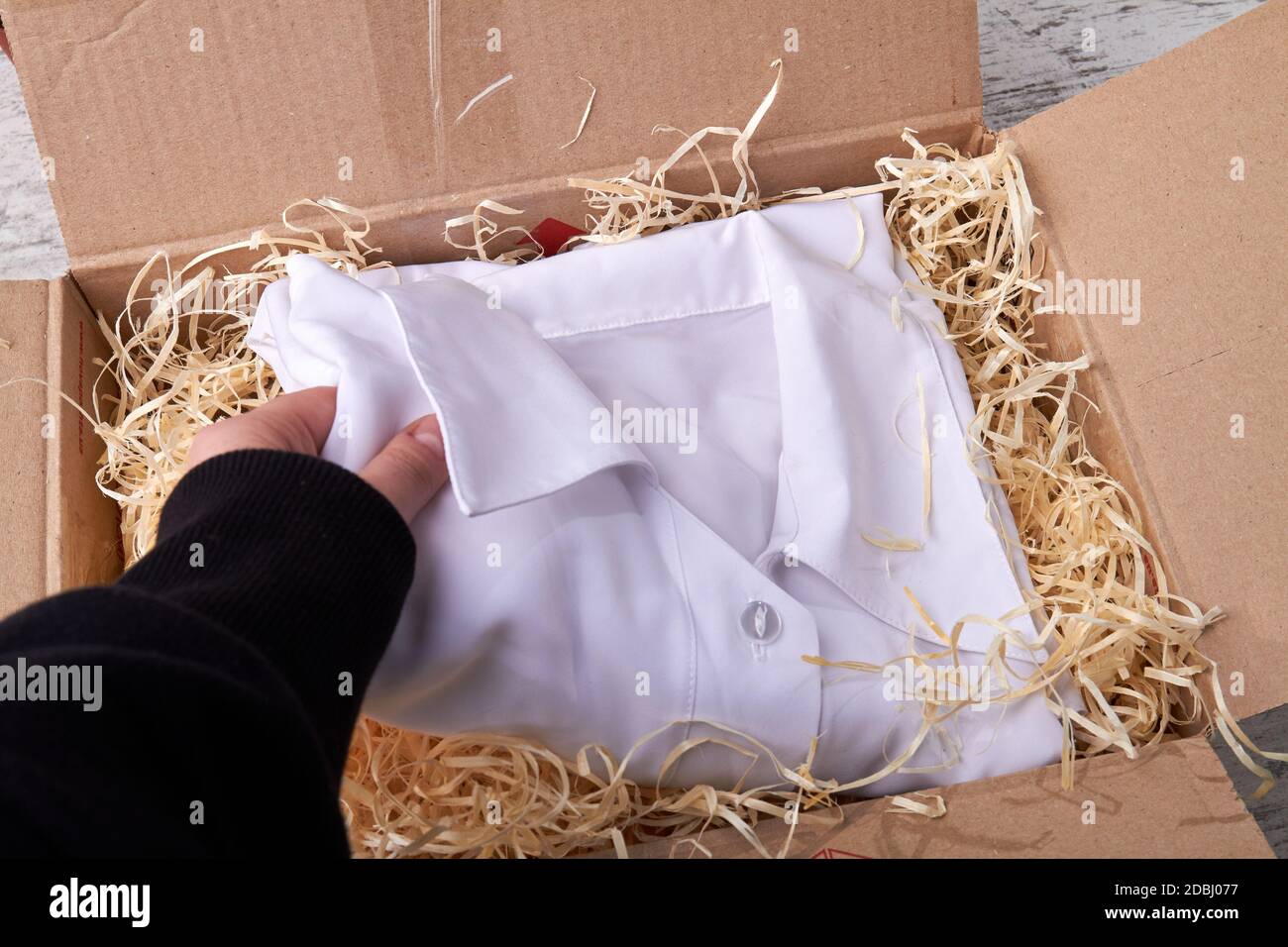 Buyer is unpacking the parcel with clothes Stock Photo - Alamy